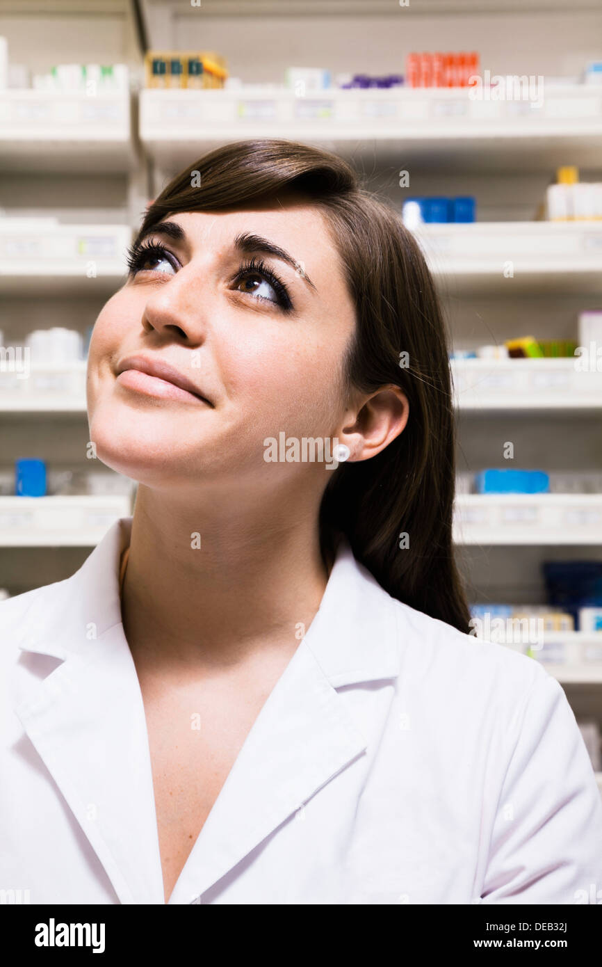 Smiling pharmacist looking up in a pharmacy Stock Photo - Alamy