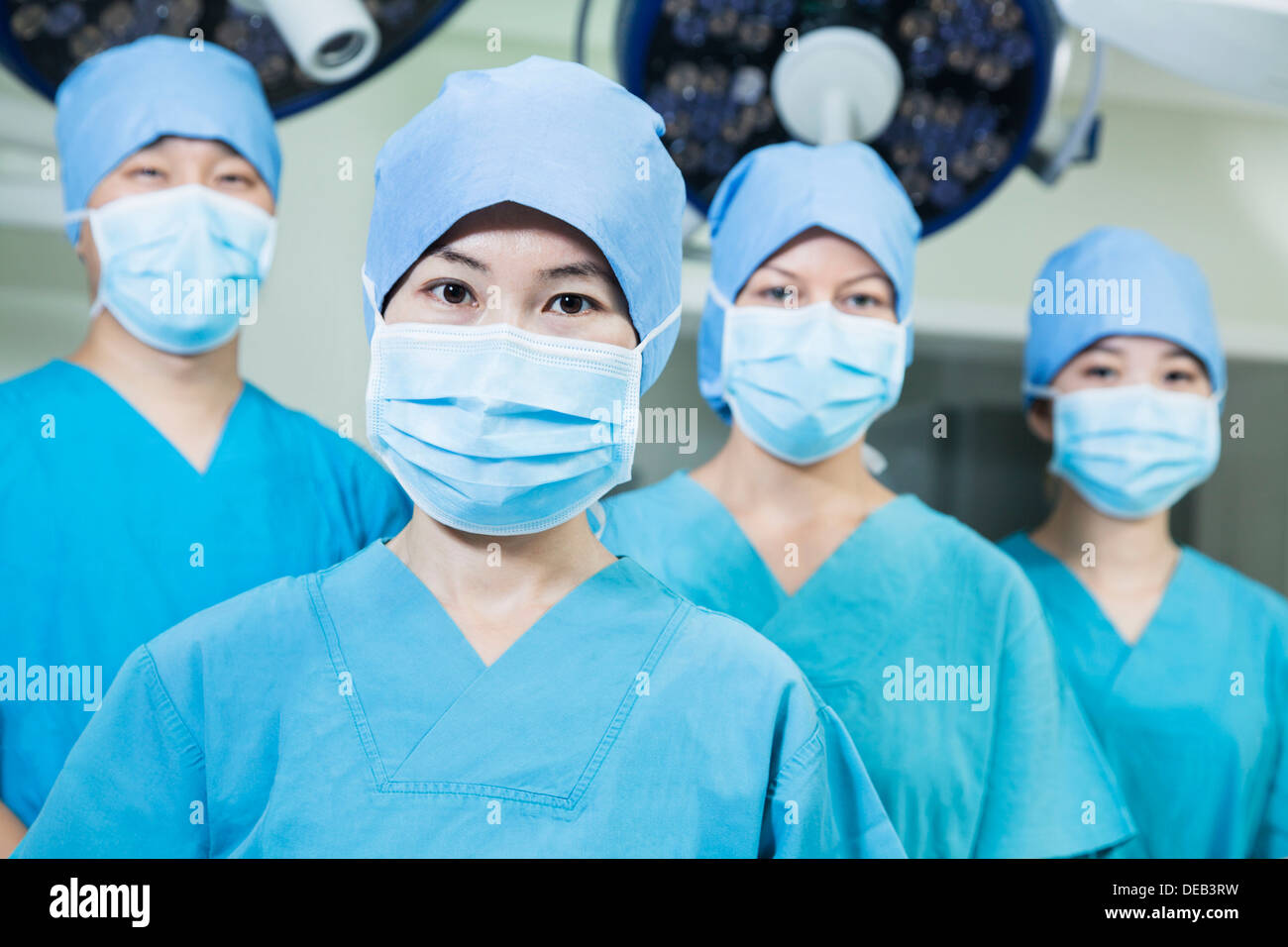 Team of surgeons wearing surgical masks in the operating room, looking ...