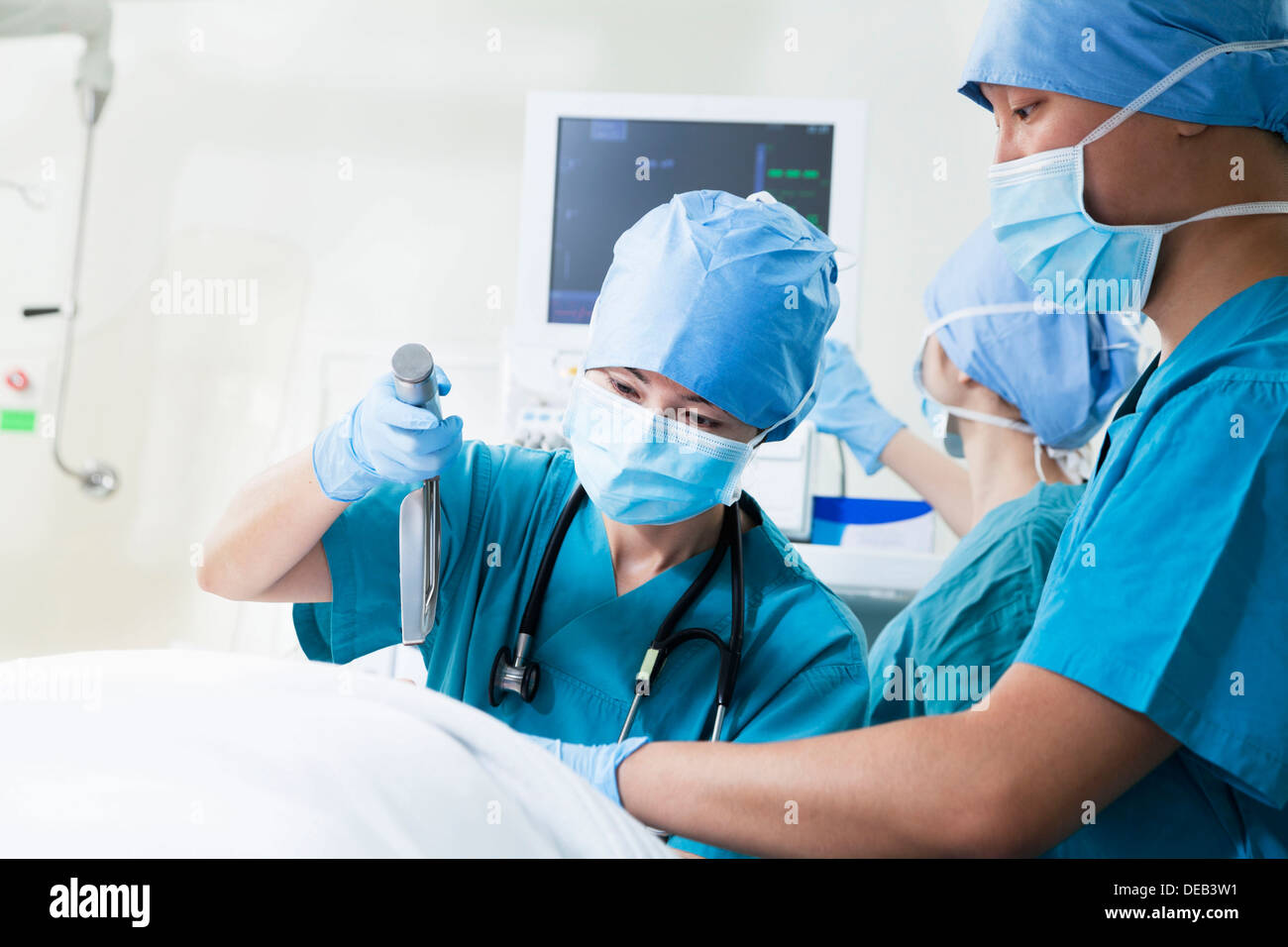 Two surgeons working at the operating table, holding surgical equipment ...