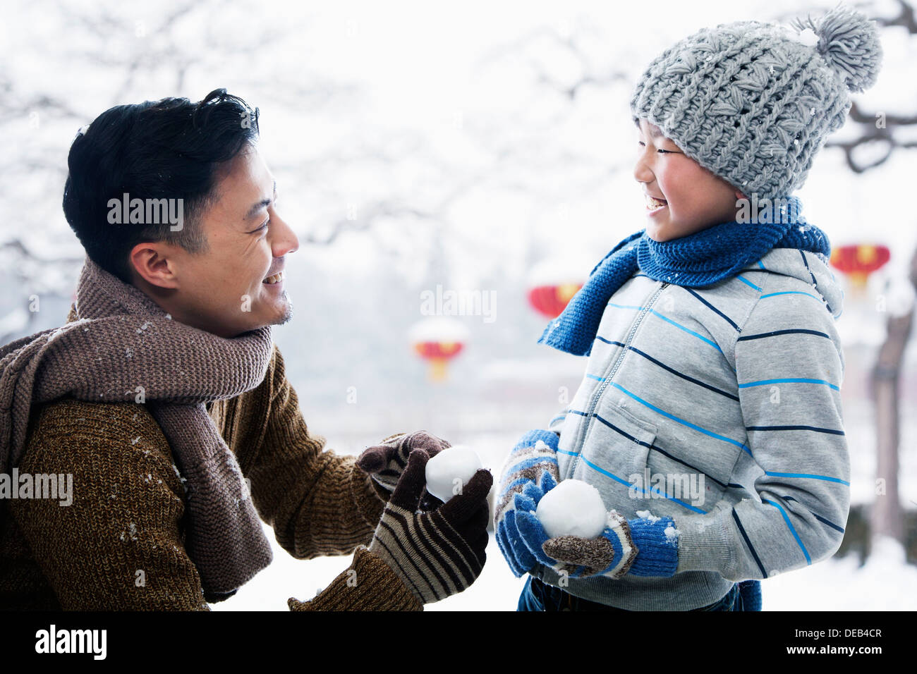 Father and son holding snowballs Stock Photo - Alamy