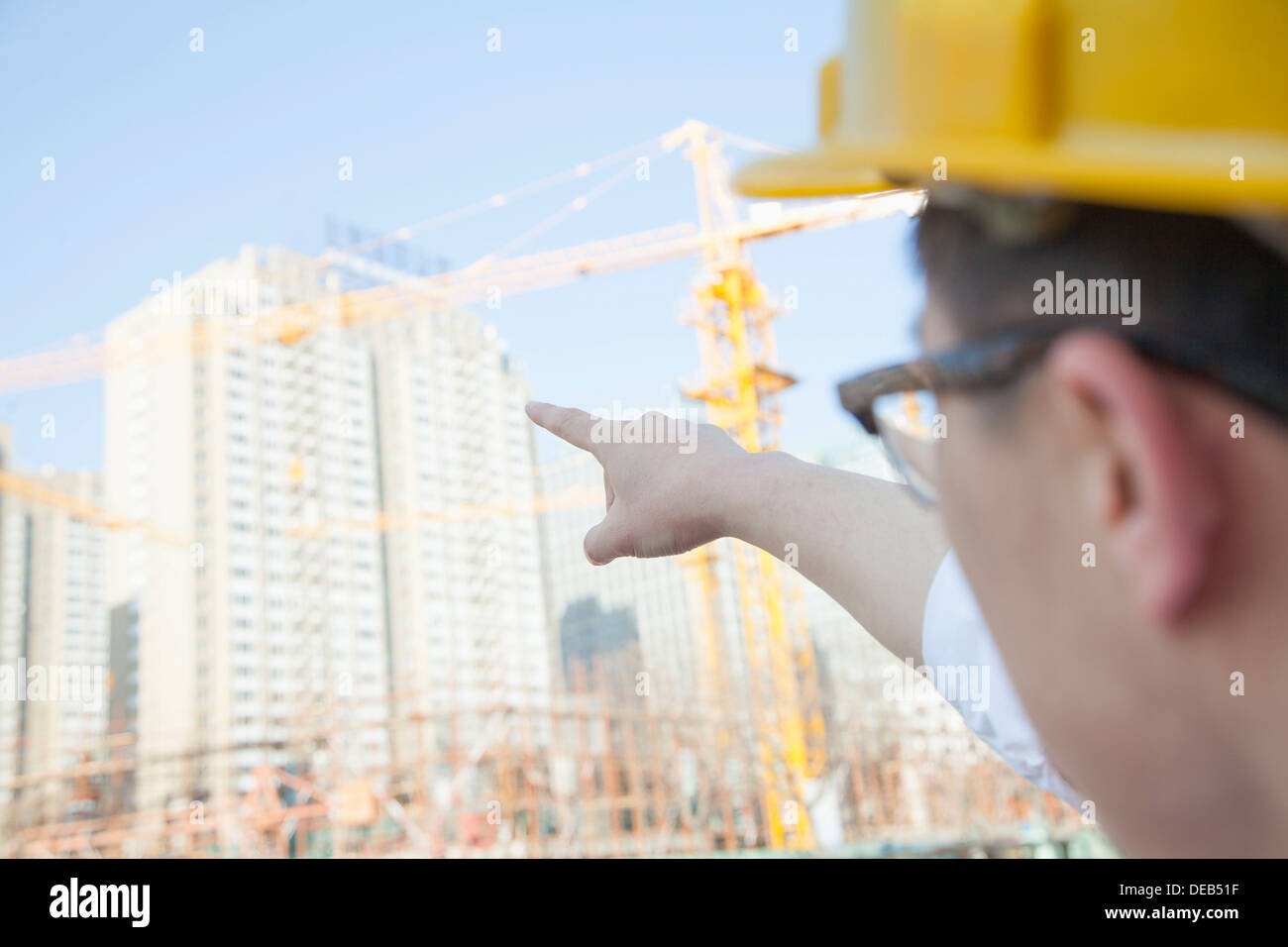 Architect on a construction site pointing at a skyscraper Stock Photo ...