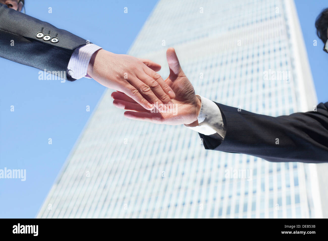 Close-up of two business people shaking hands by the World Trade Center ...