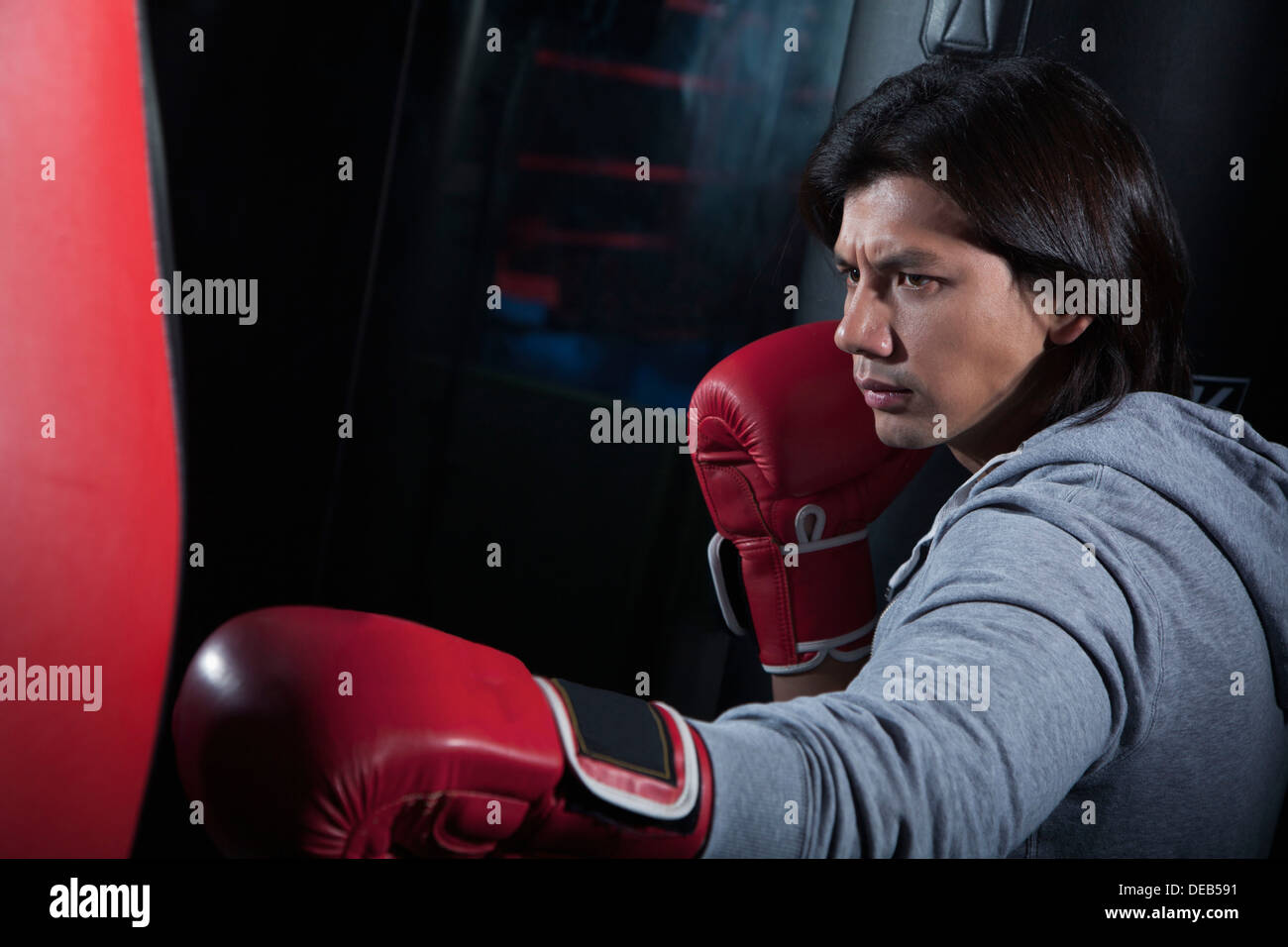 Determined boxer training at the gym on the punch bag Stock Photo - Alamy
