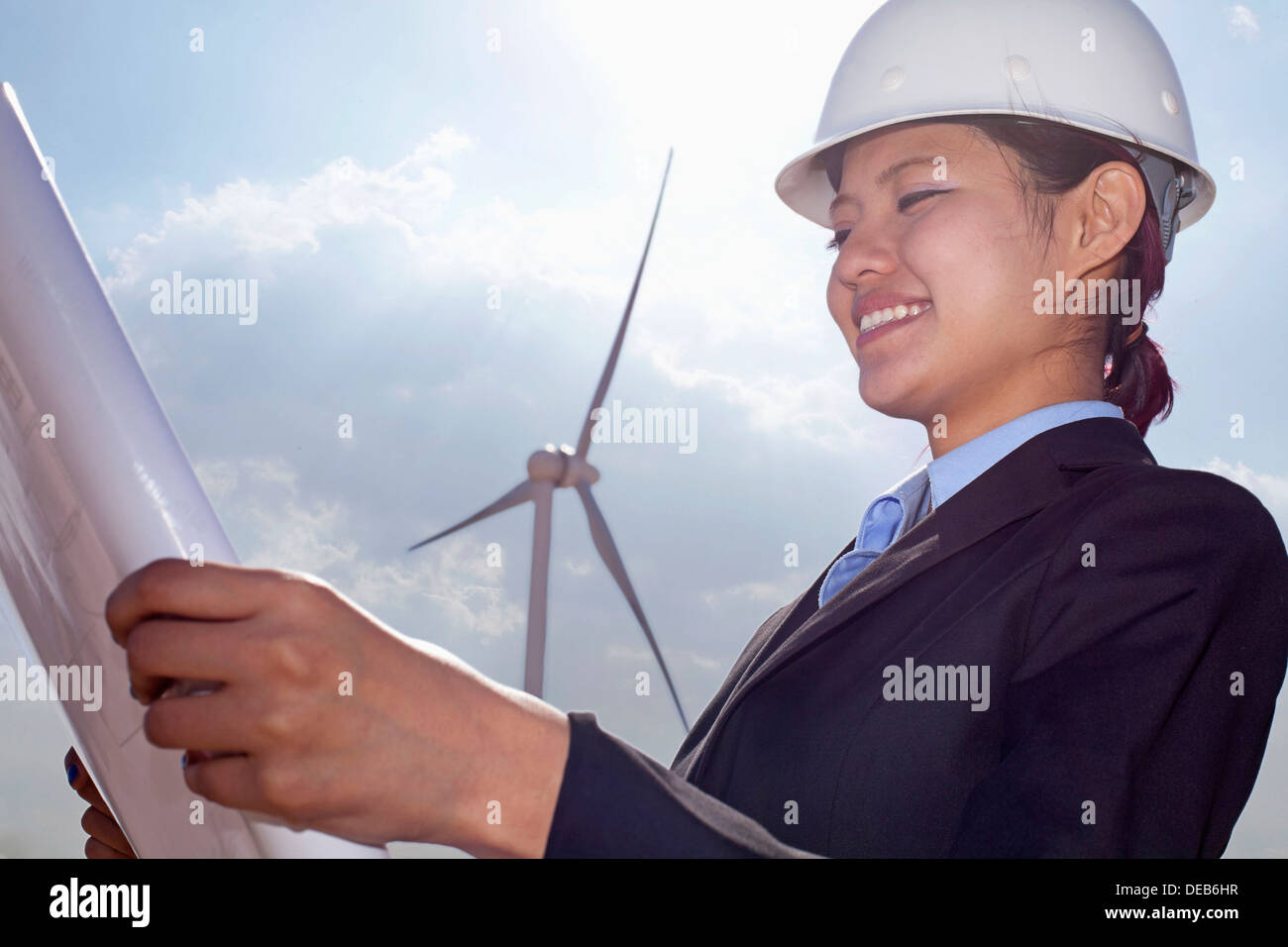 Young smiling female engineer holding open and looking down at ...