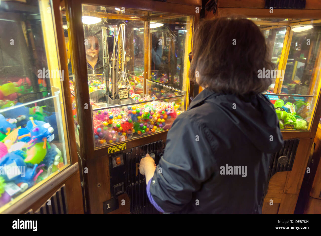 A middle aged woman playing games in an arcade and trying to win a ...