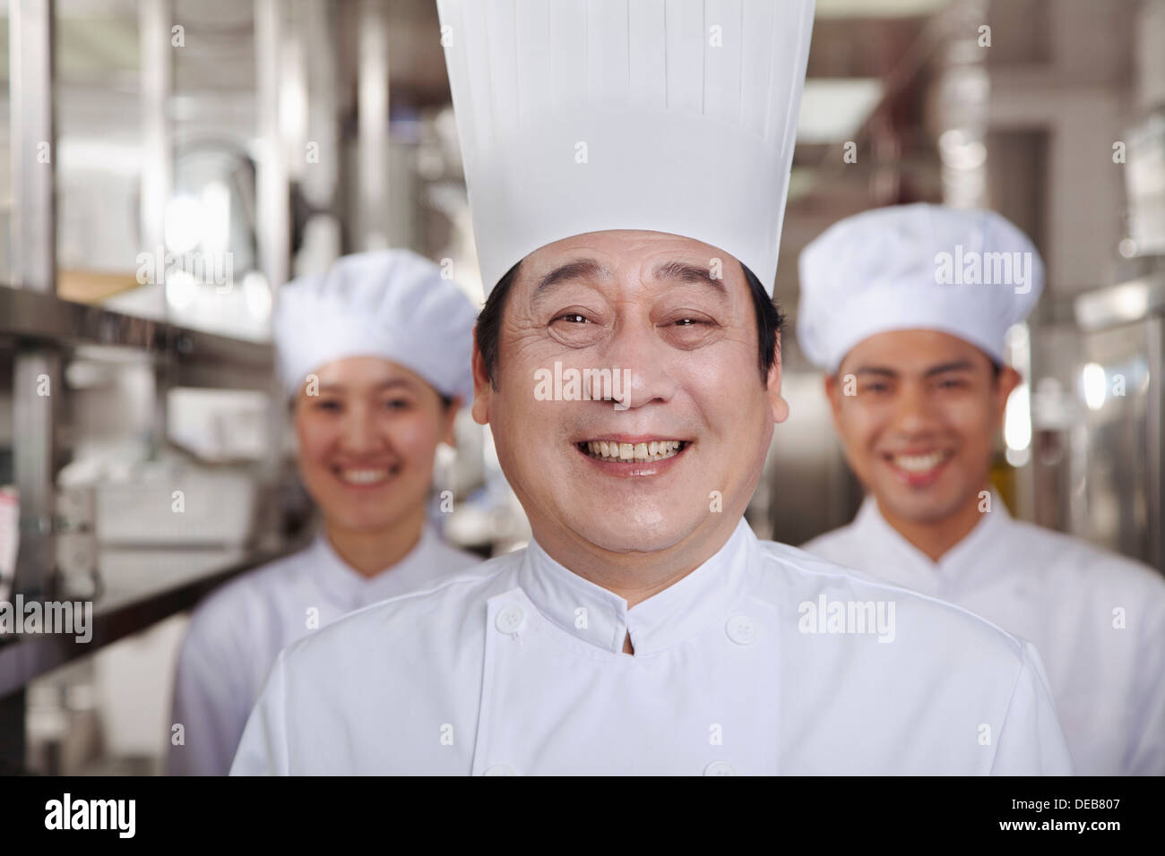 Three Chefs in an Industrial Kitchen Stock Photo - Alamy