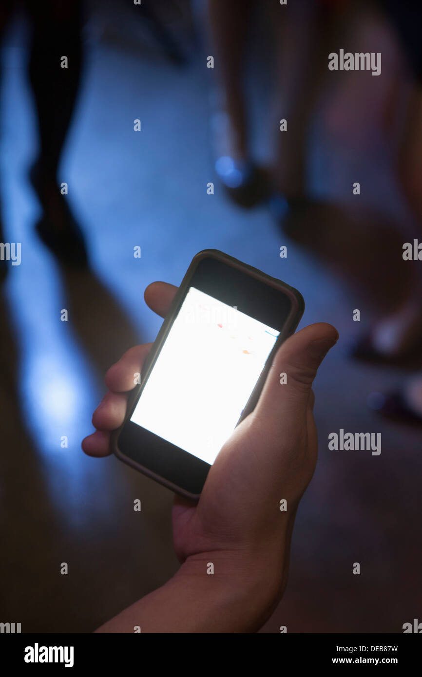 A young man uses a mobile phone in nightclub Stock Photo - Alamy