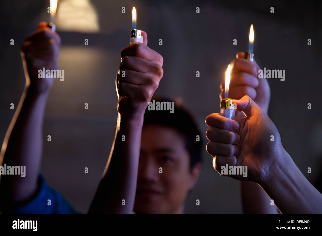 Group of people holding cigarette lighters at a concert Stock Photo - Alamy