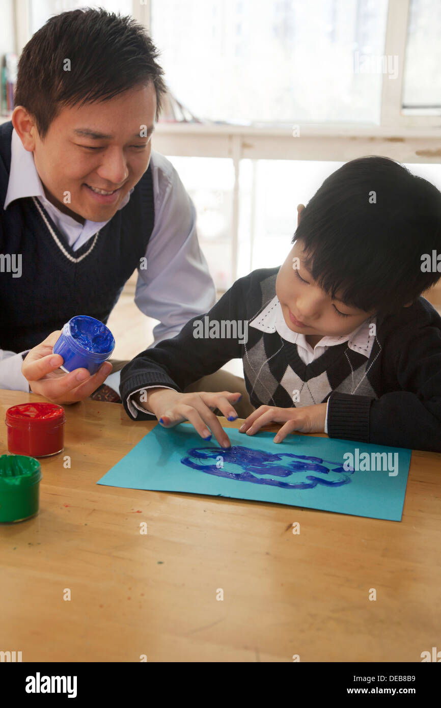 Teacher and student finger painting in art class Stock Photo - Alamy