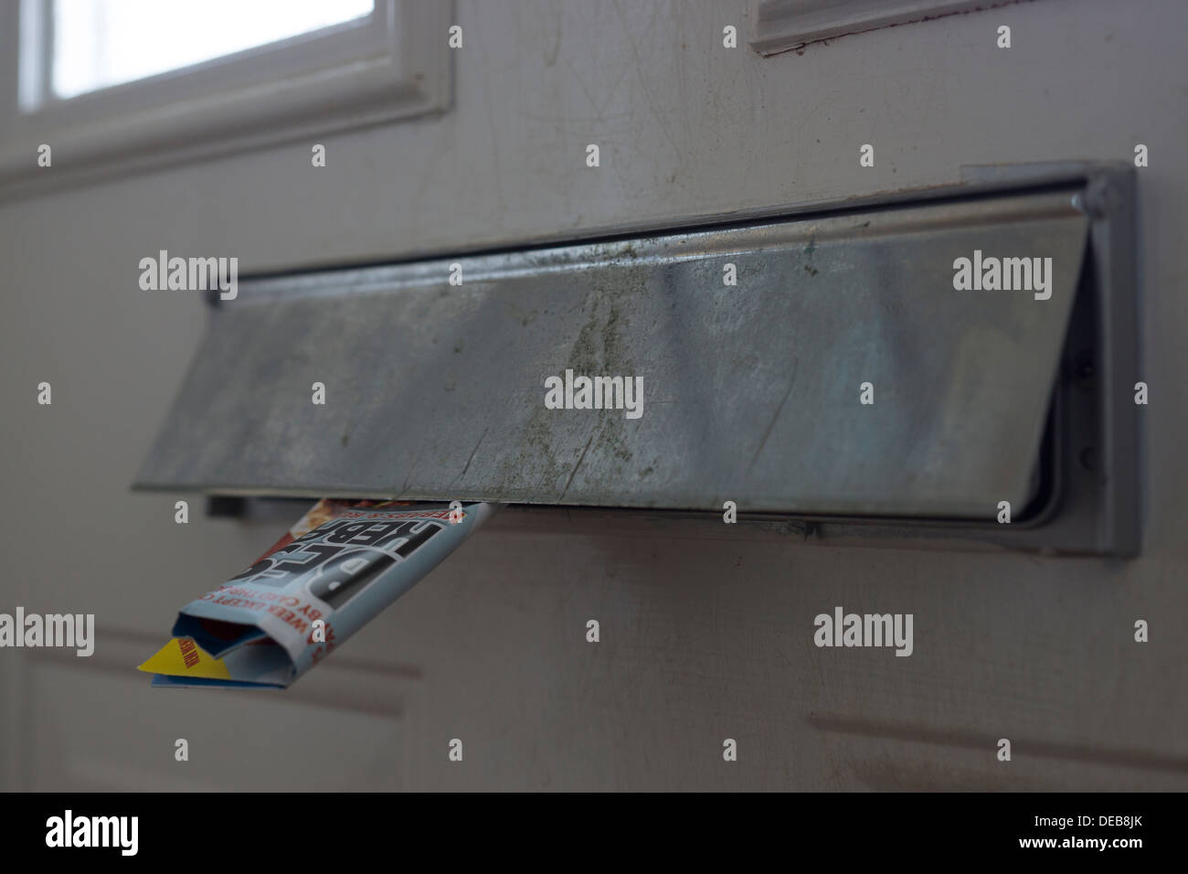 Junk mail letter box dirty white door sun window Stock Photo - Alamy