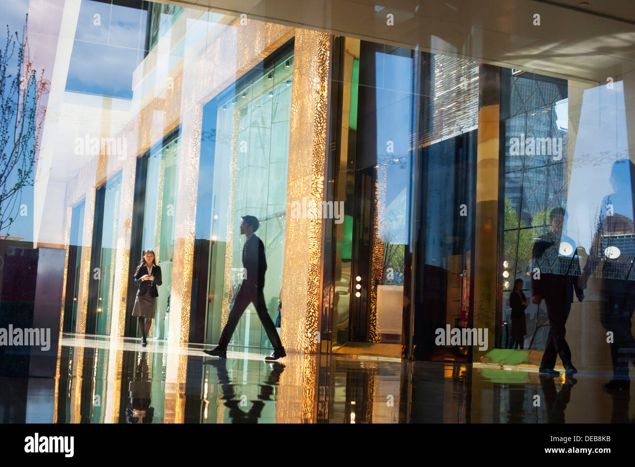 Business People walking through the lobby of an office building on the ...