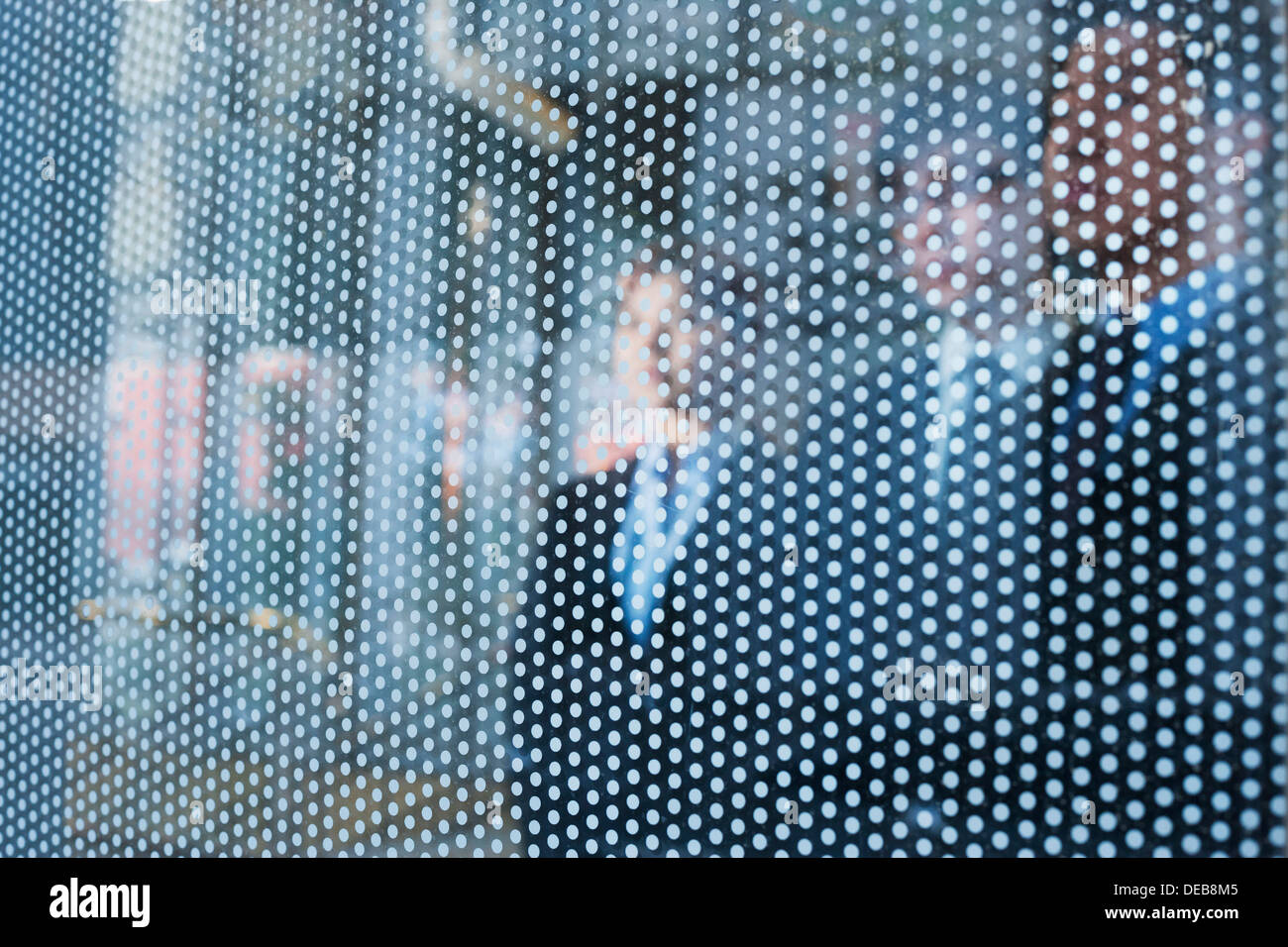 Three business people behind a glass wall looking out, unrecognizable ...