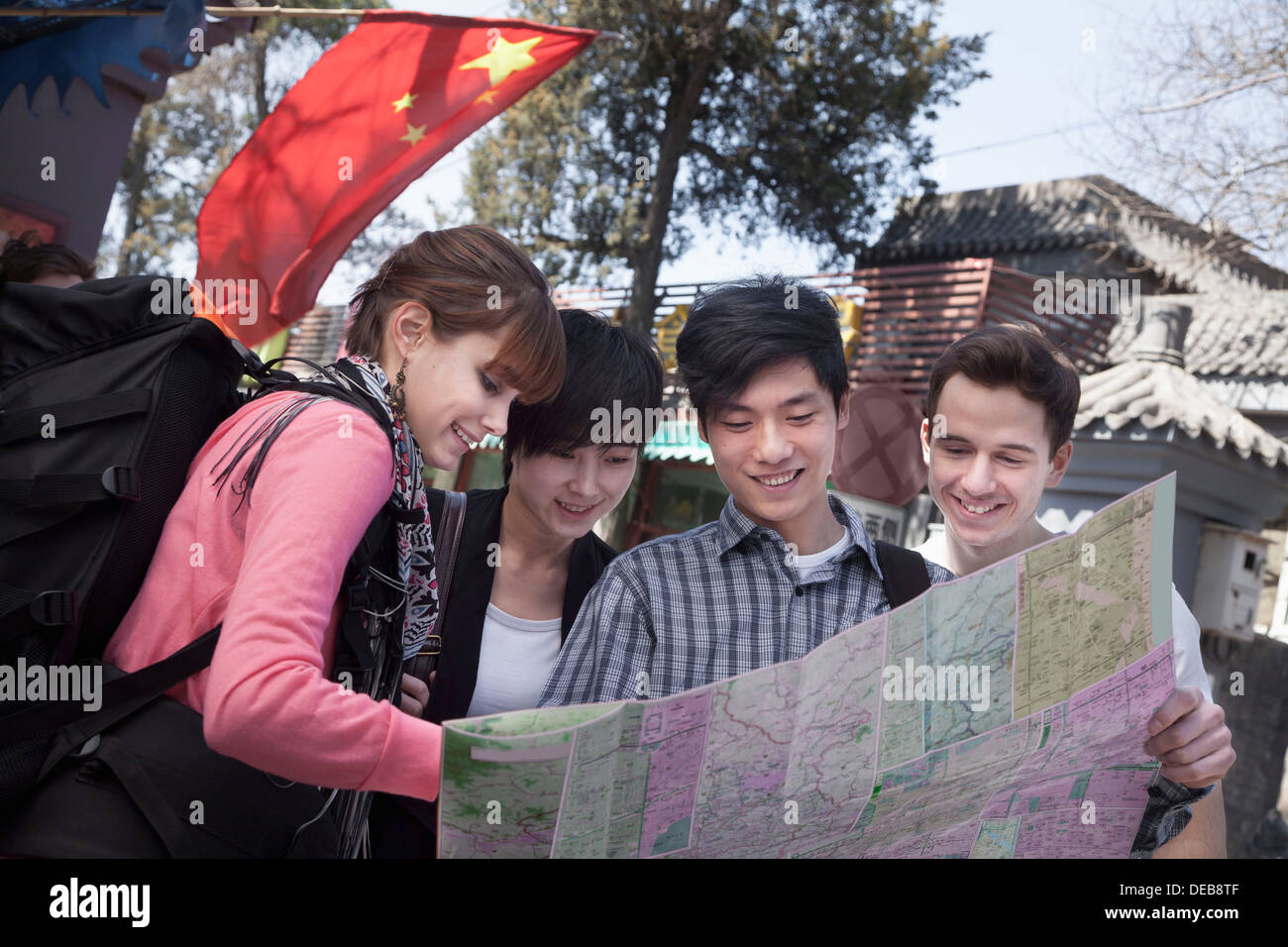 Four young people looking at map Stock Photo - Alamy