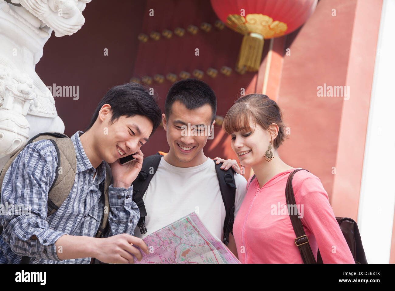 Three people looking at map Stock Photo - Alamy