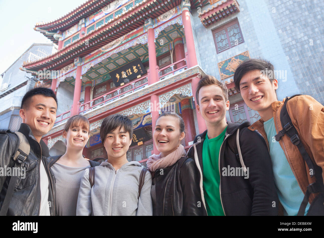 Group of young people with Chinese architecture in background, portrait ...