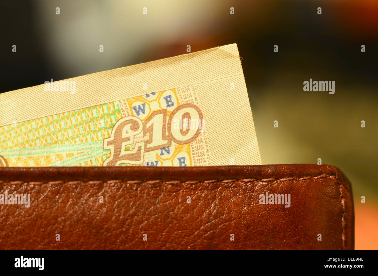 ten pound note sticking out of a leather wallet Stock Photo - Alamy