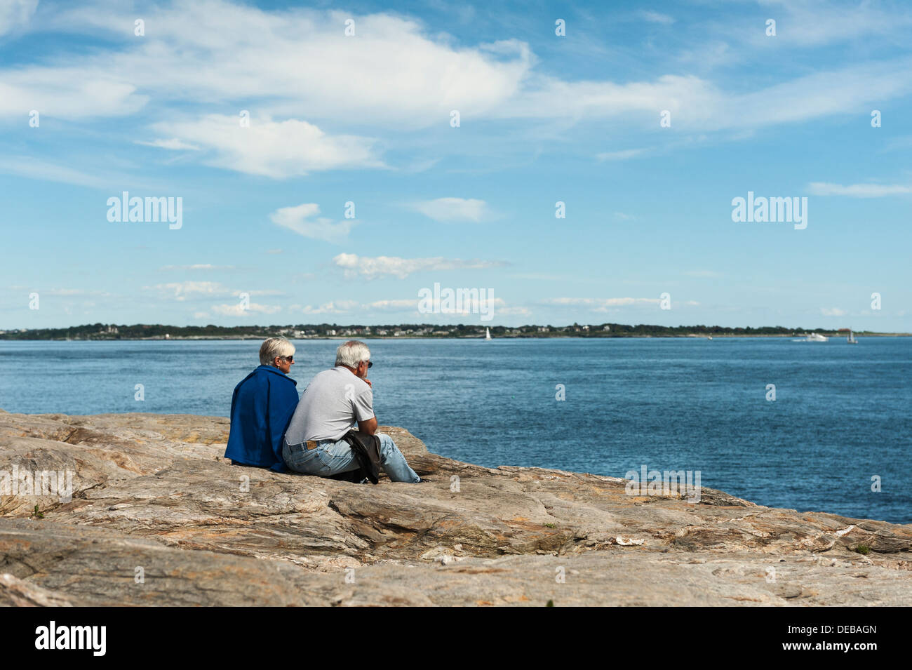 An older couple sitting on the rocks overlooking the Ocean in Point ...