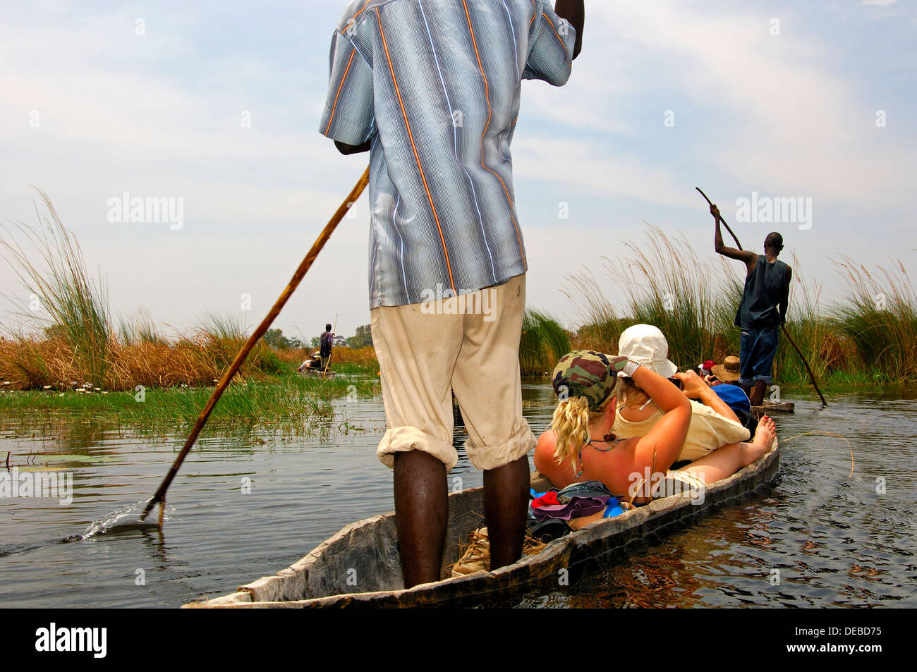 Tourists on a trip in a Mokoro canoe in the Okavango Delta, Botswana ...