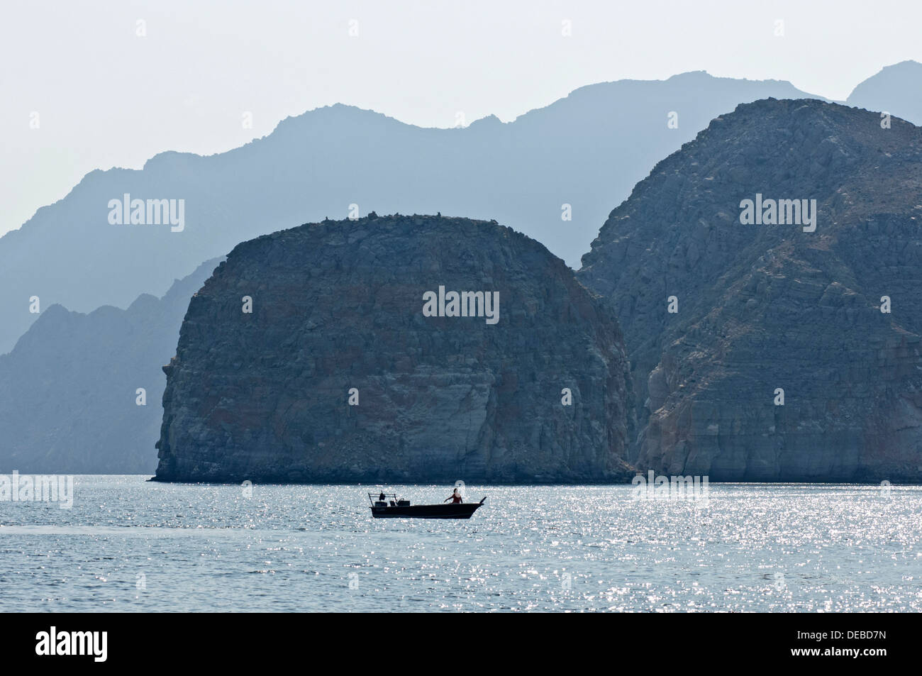 Khor Ash Sham Fjord with a fishing boat, backlit, Musandam Governorate ...