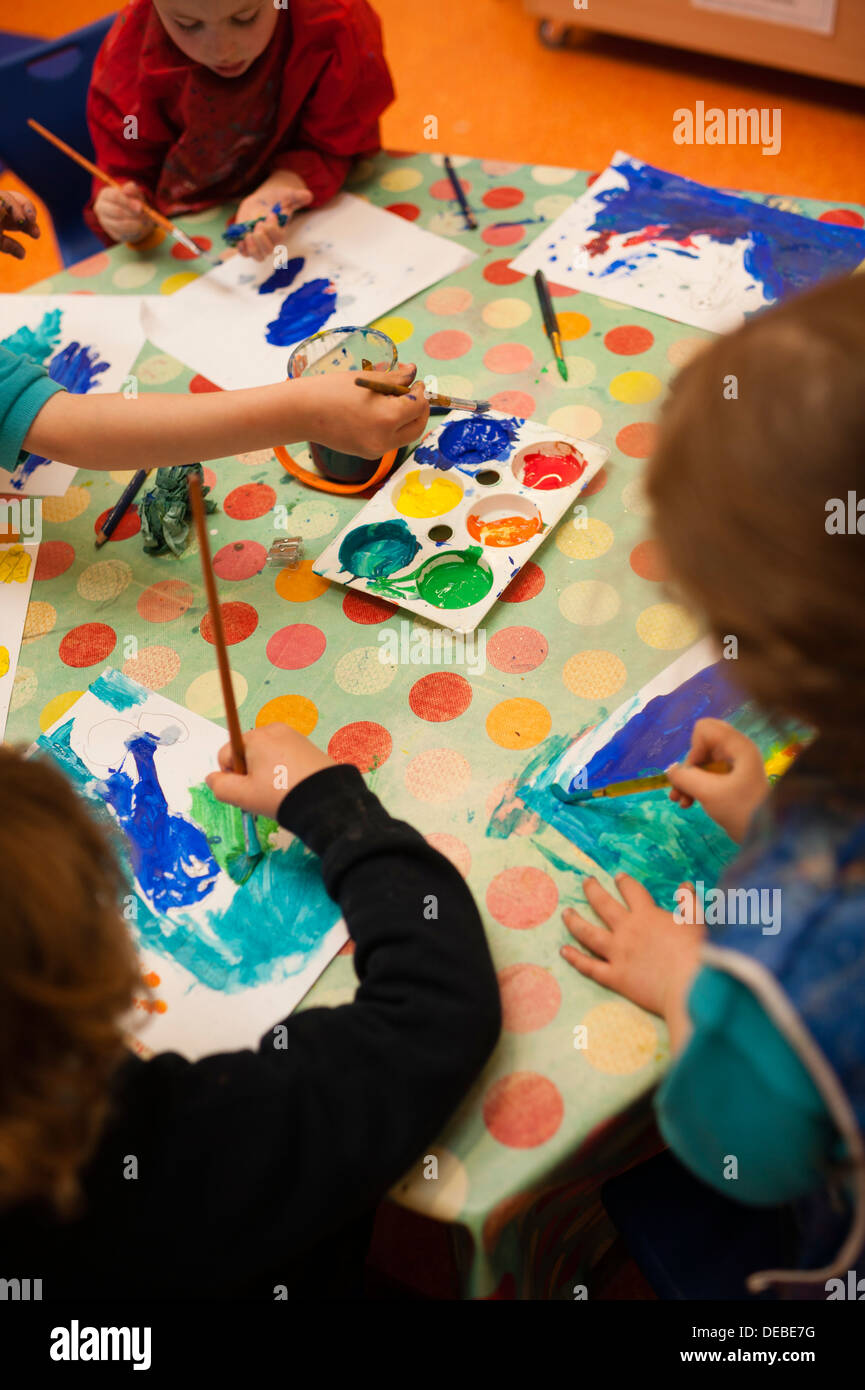 Pupils painting in an art class lesson in a primary school, Wales UK ...