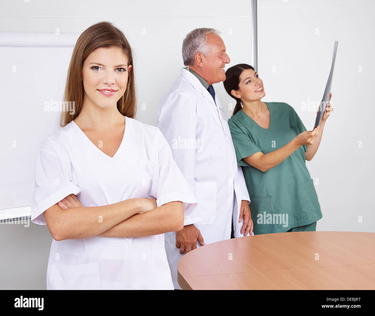 Young happy nurse with her arms crossed in a team in a hospital Stock ...