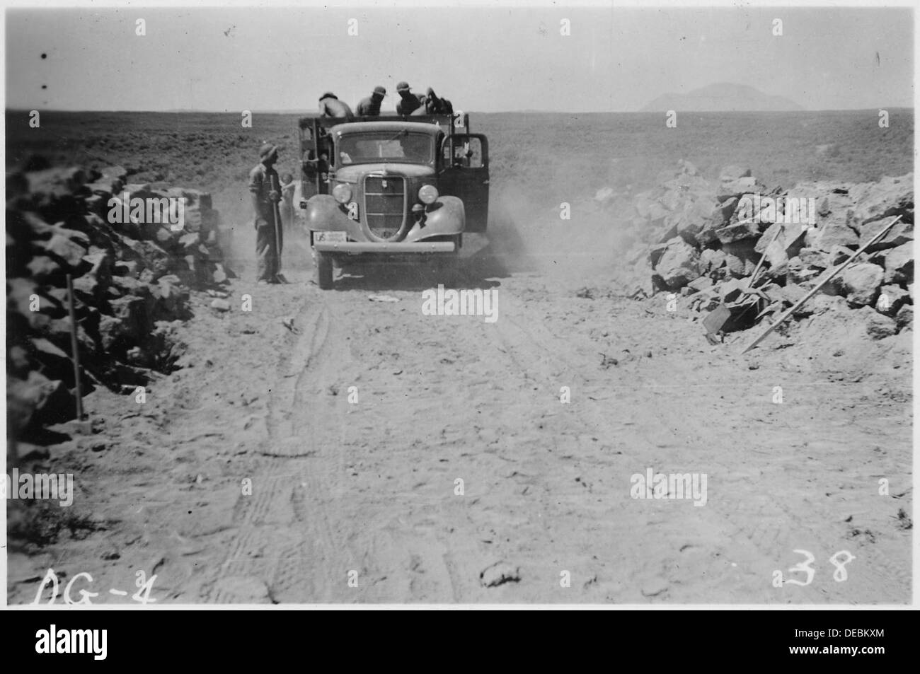 A crew works to surface truck trails after excavation has been ...
