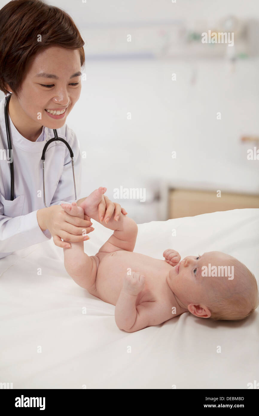 Smiling doctor examining a baby in the doctors office Stock Photo - Alamy