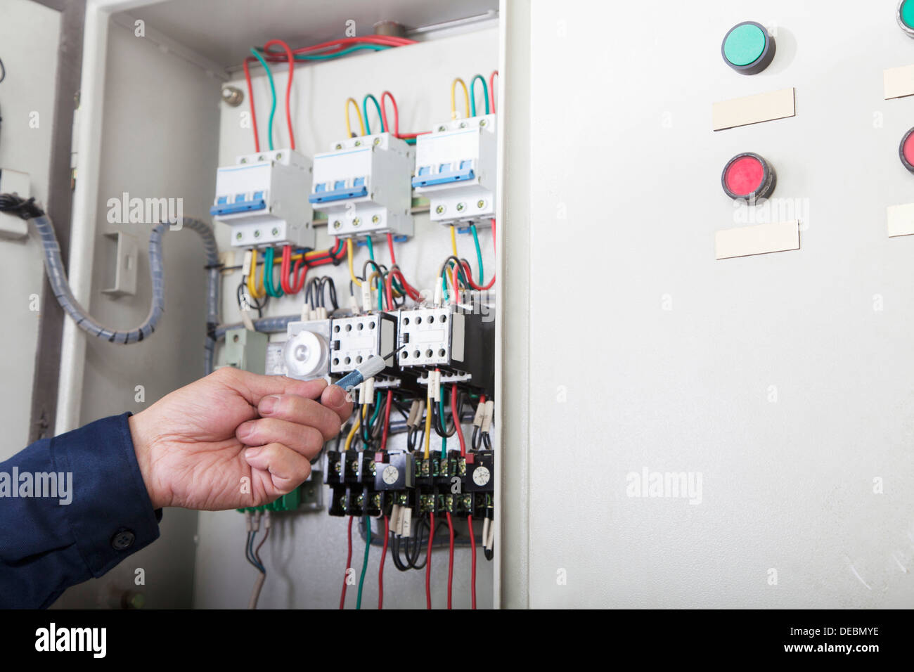 Close-up of workers hand checking the controls and wiring in a gas ...