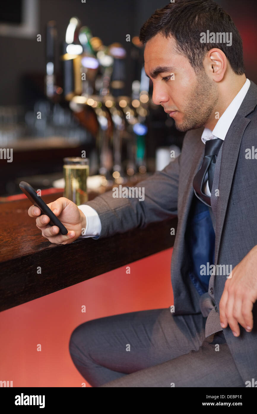 Handsome businessman sending a text while having a drink Stock Photo ...
