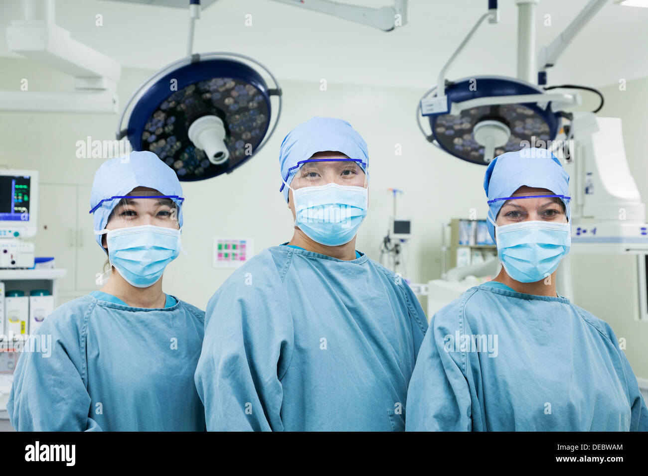 Portrait of three surgeons in a row wearing surgical masks in the ...
