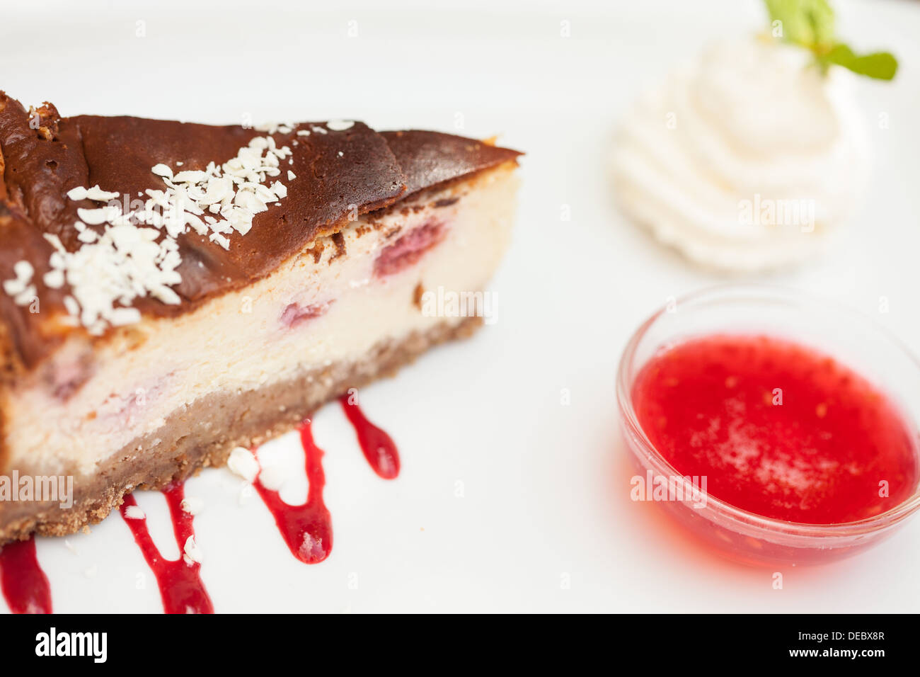 Cheesecake with chantilly cream and coulis close up Stock Photo - Alamy