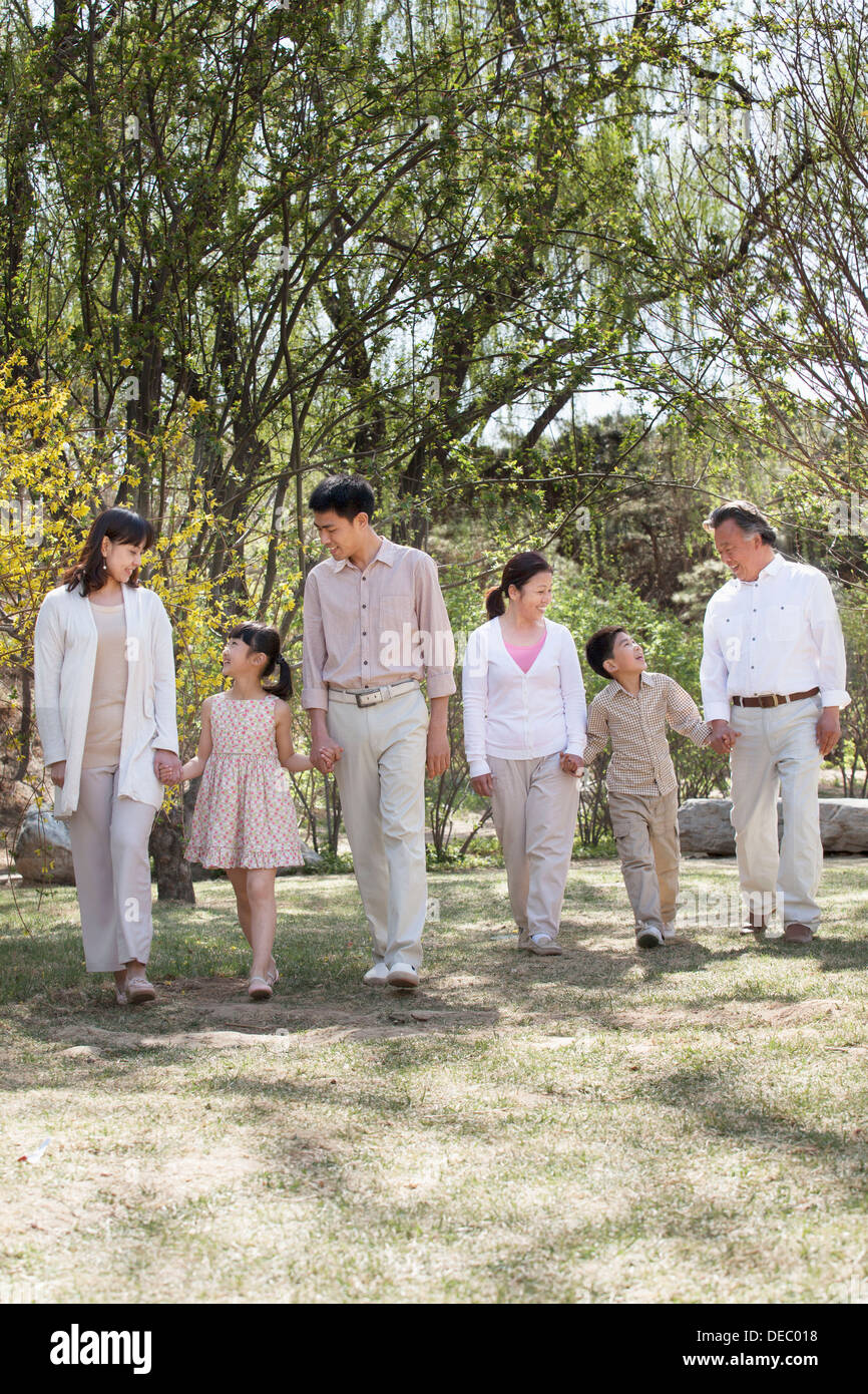 Happy smiling family holding hands and going for a walk in the ...