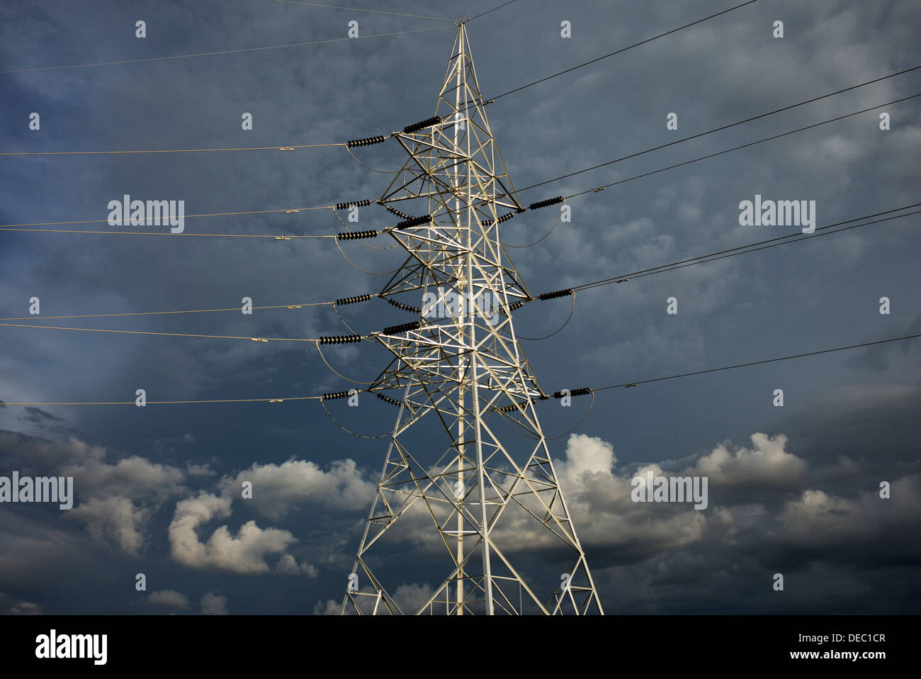 Electricity pylon and cables in the Indian countryside against a dark ...
