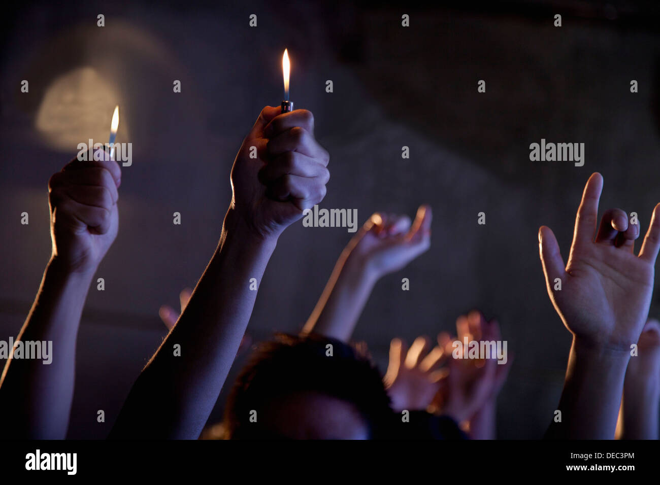 Group of people holding cigarette lighters at a concert Stock Photo - Alamy