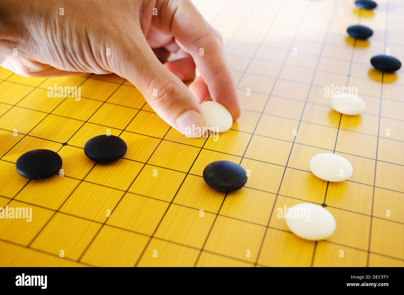 A male hand places a go stone on the board in a game of go Stock Photo ...