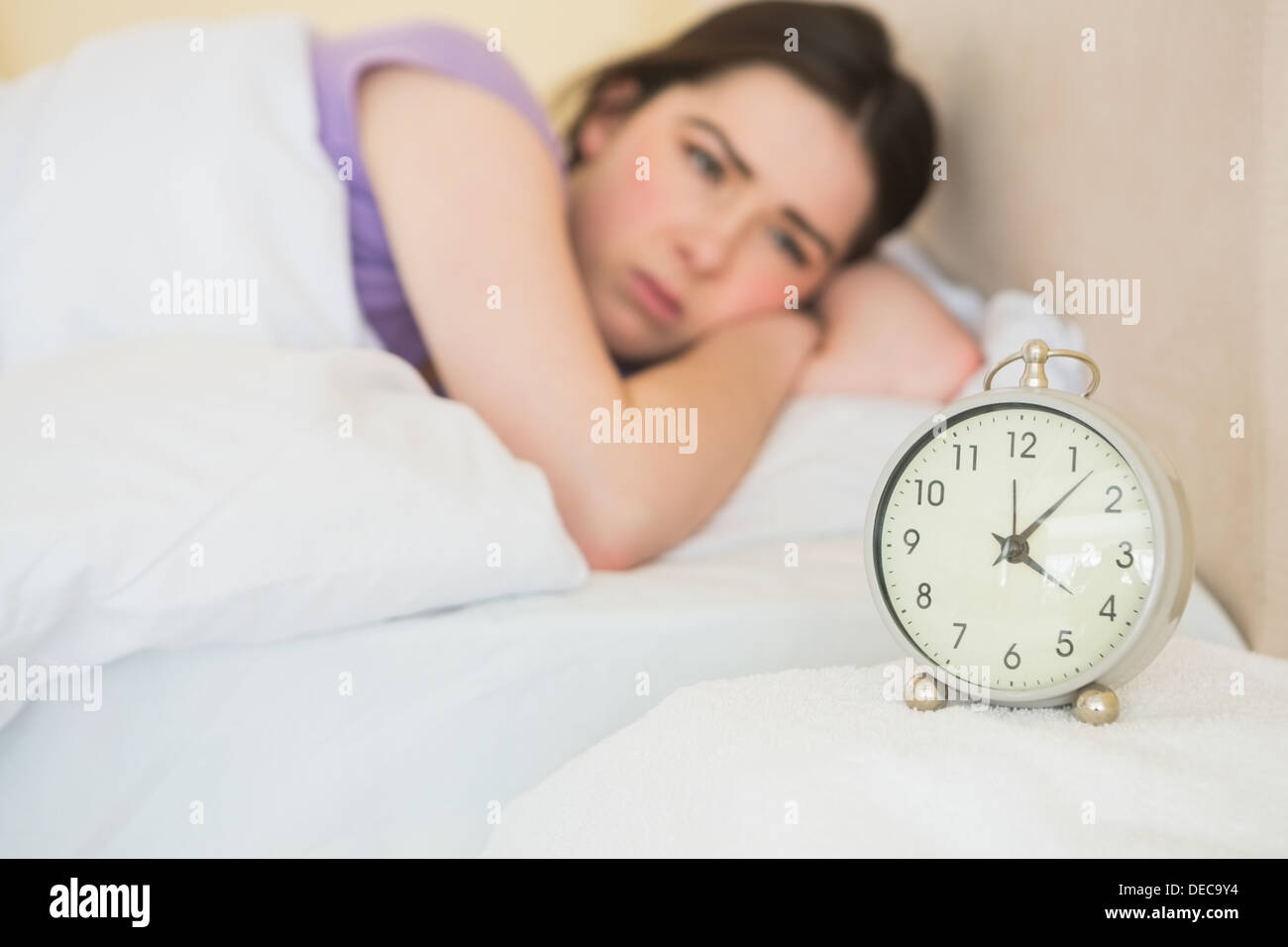 Exhausted girl waking up in her bed Stock Photo - Alamy