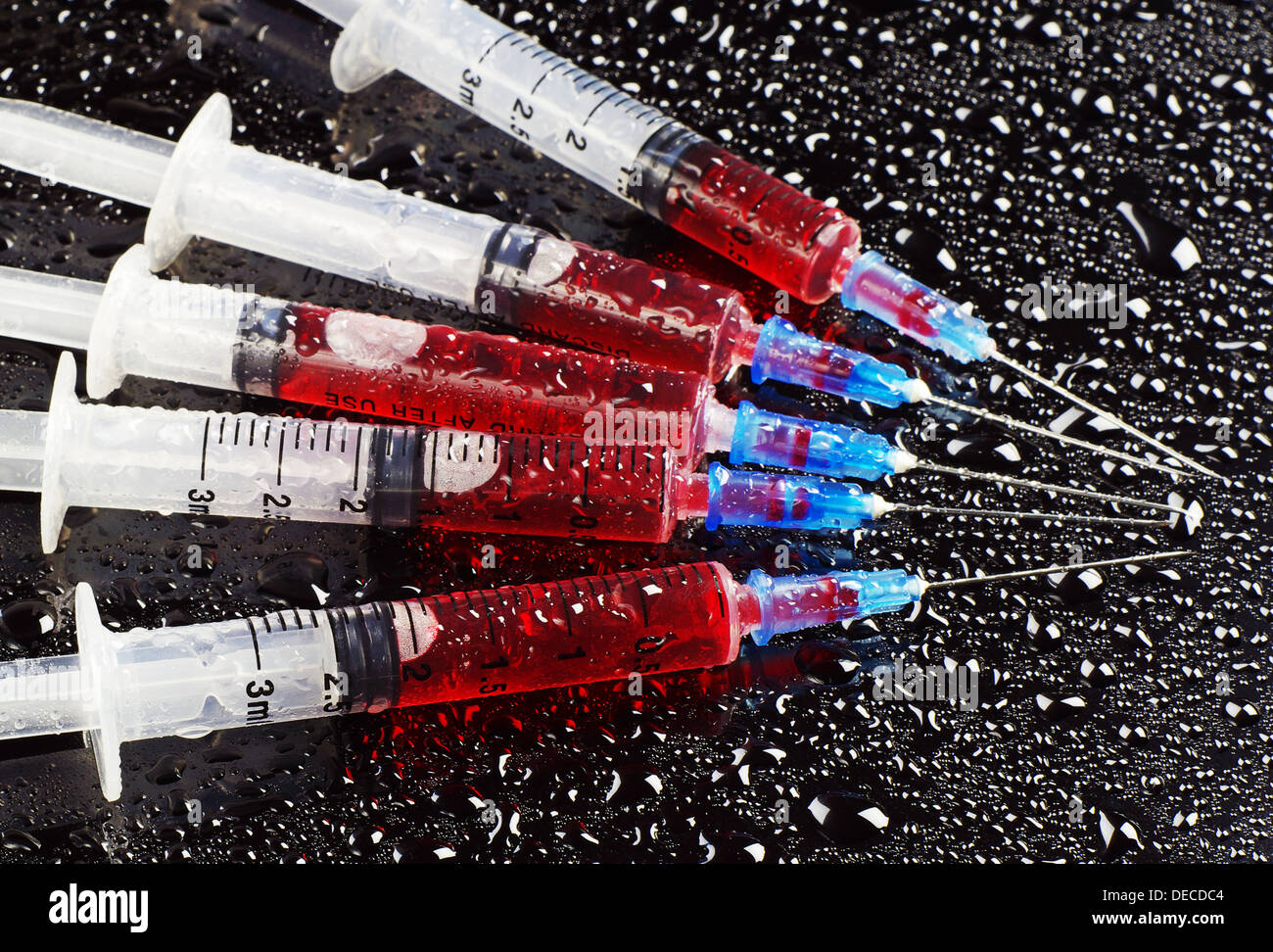 Medical syringes closeup and water drops on black Stock Photo - Alamy