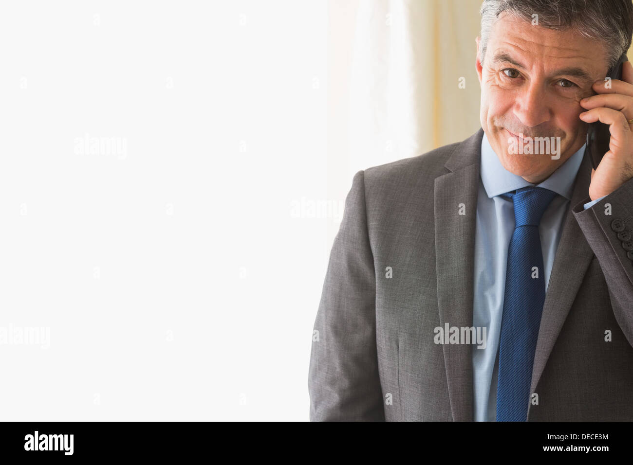 Amused man calling someone with his mobile phone Stock Photo - Alamy
