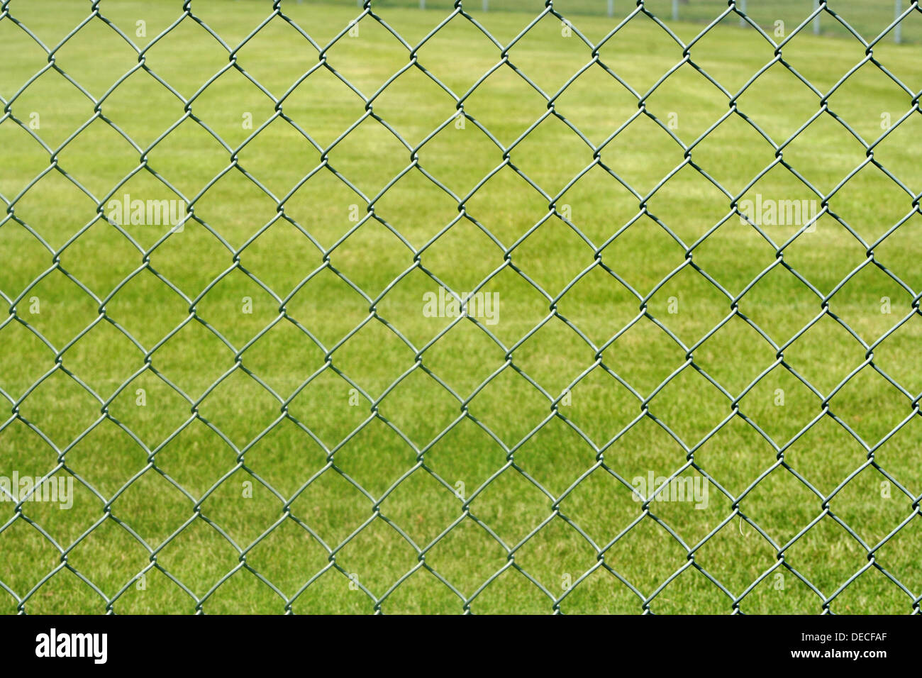 A chain link fence crossing a field of grass in a park in Altona ...