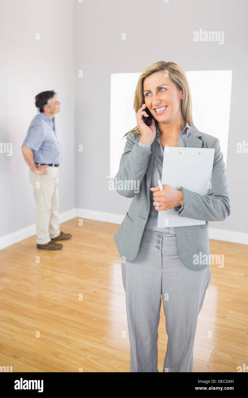 Smiling realtor calling someone with her mobile phone Stock Photo - Alamy