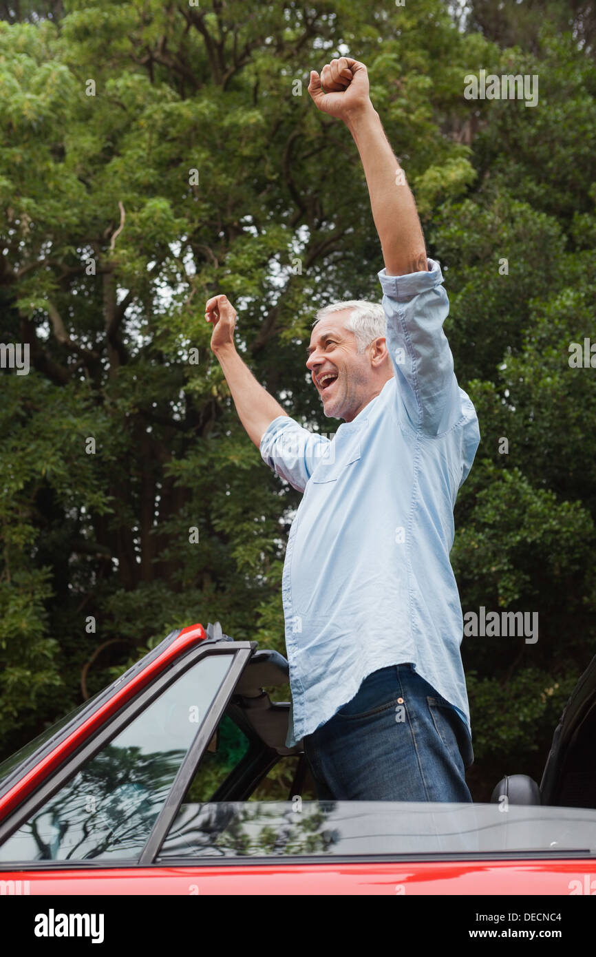 Happy mature man enjoying his red convertible Stock Photo - Alamy