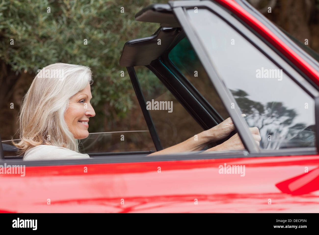 Happy mature woman driving red convertible Stock Photo - Alamy
