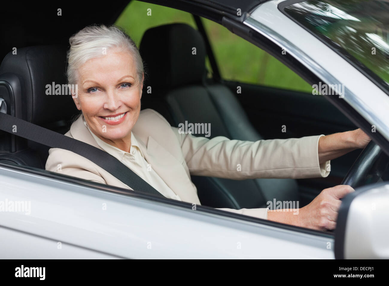 Cheerful businesswoman driving classy car Stock Photo - Alamy