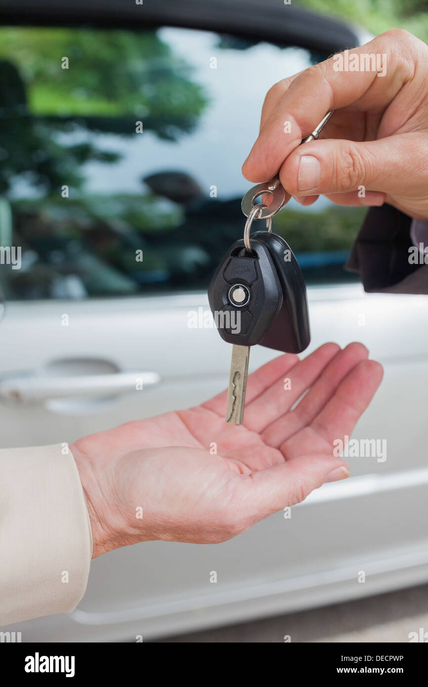 Close up on business man giving his keys to his female partner Stock ...