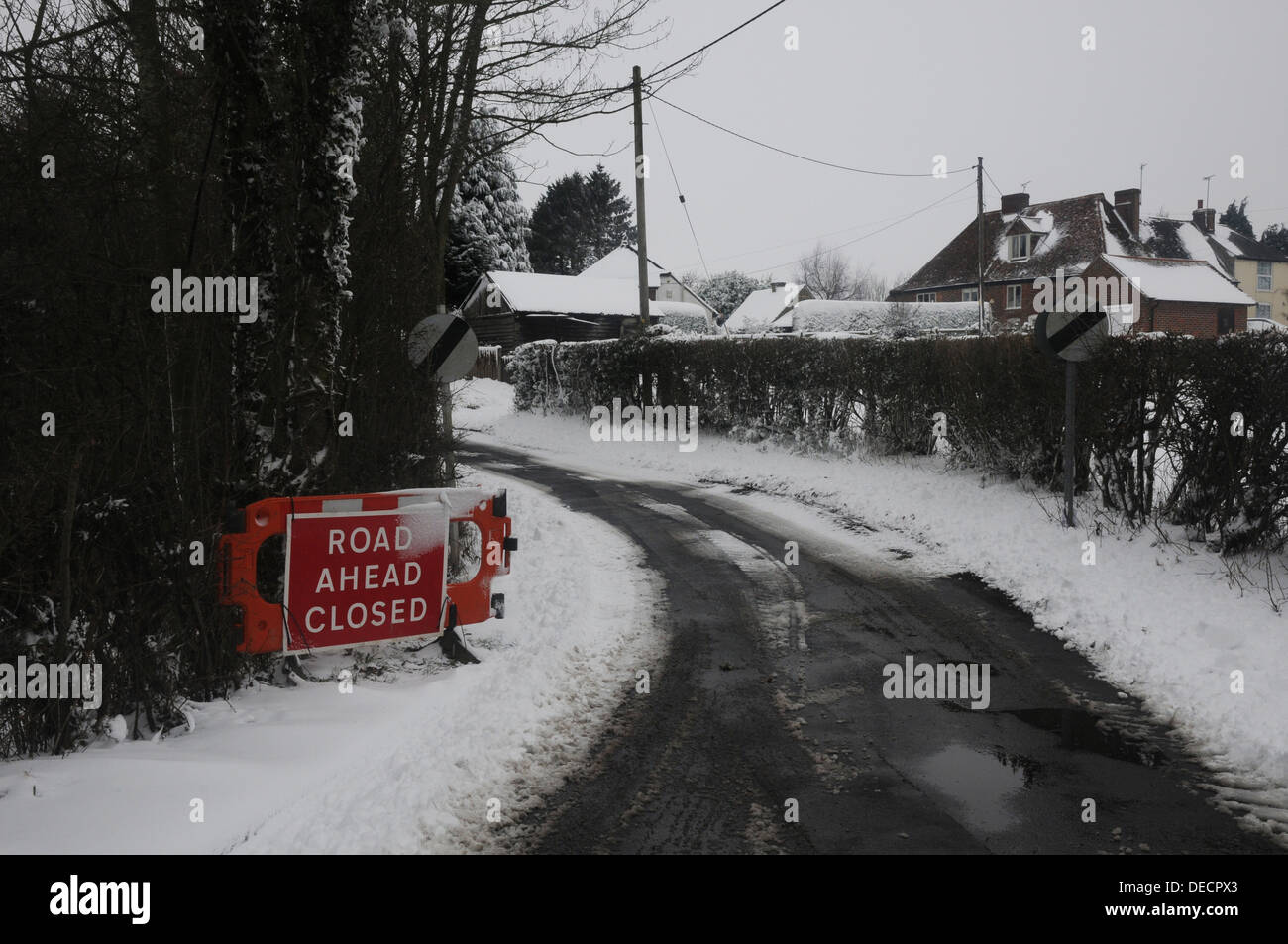 Road sign in bleak winter snowy, slushy, wet landscape, houses in ...