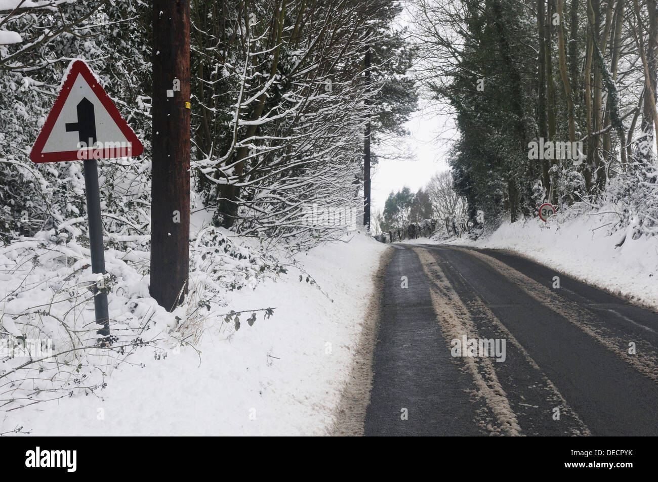 wet, slushy country road in snowy landscape, road sign, danger Stock ...