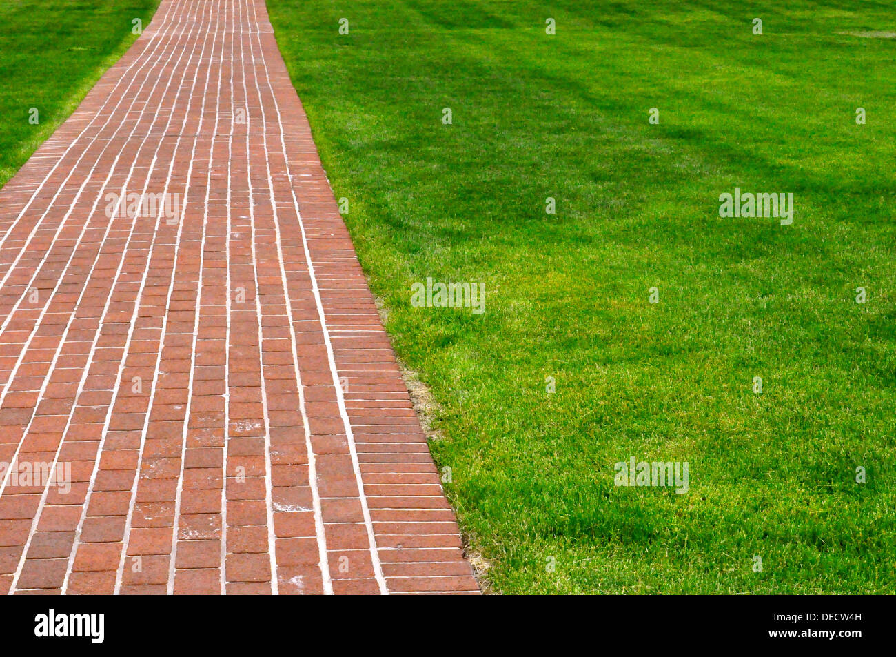 Brick pathway along green grass Stock Photo - Alamy
