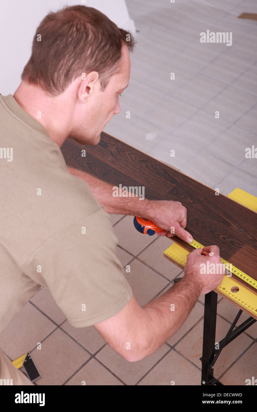 Man marking off laminate flooring with pencil Stock Photo - Alamy