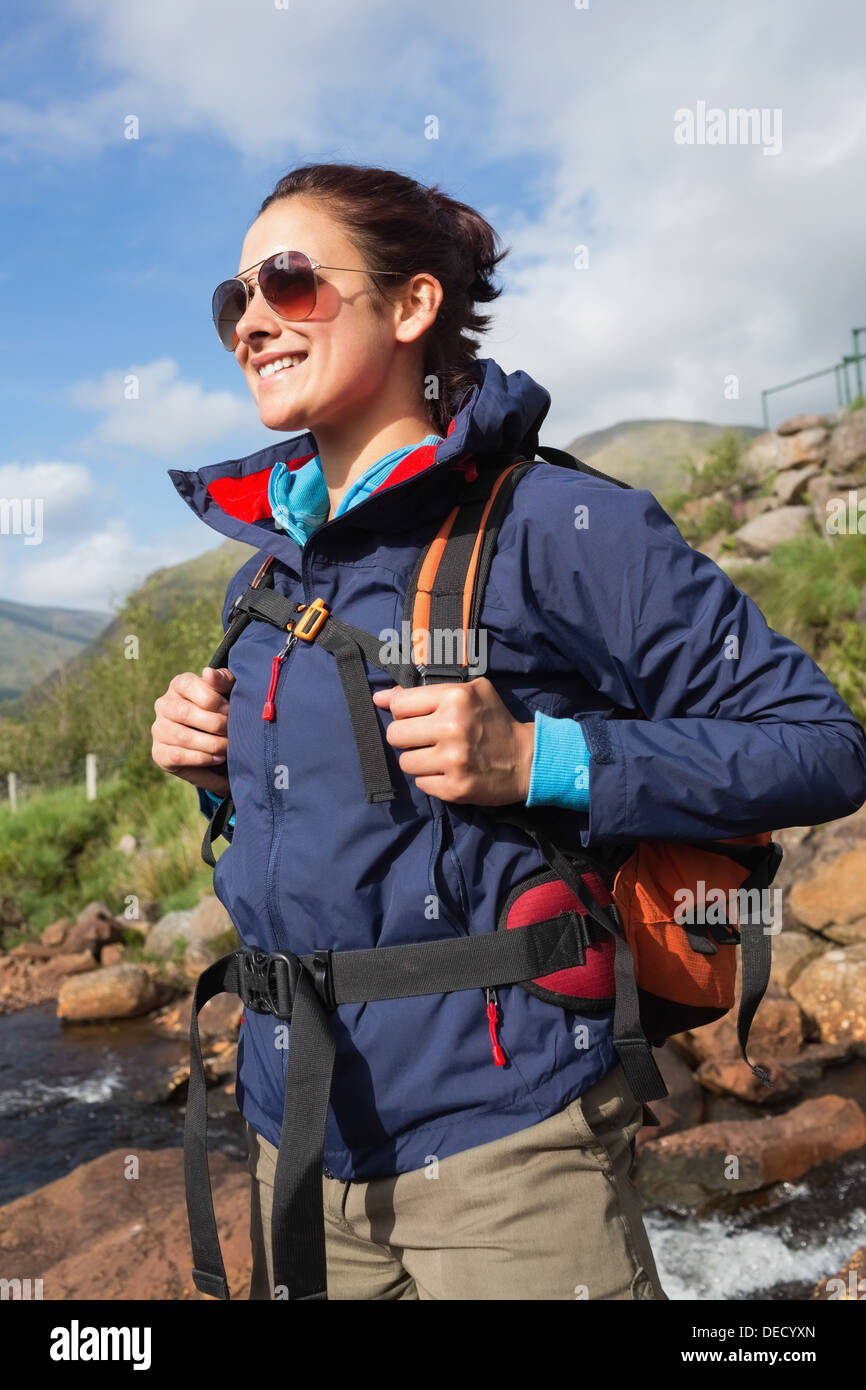 Brunette wearing rain jacket and sunglasses smiling Stock Photo - Alamy