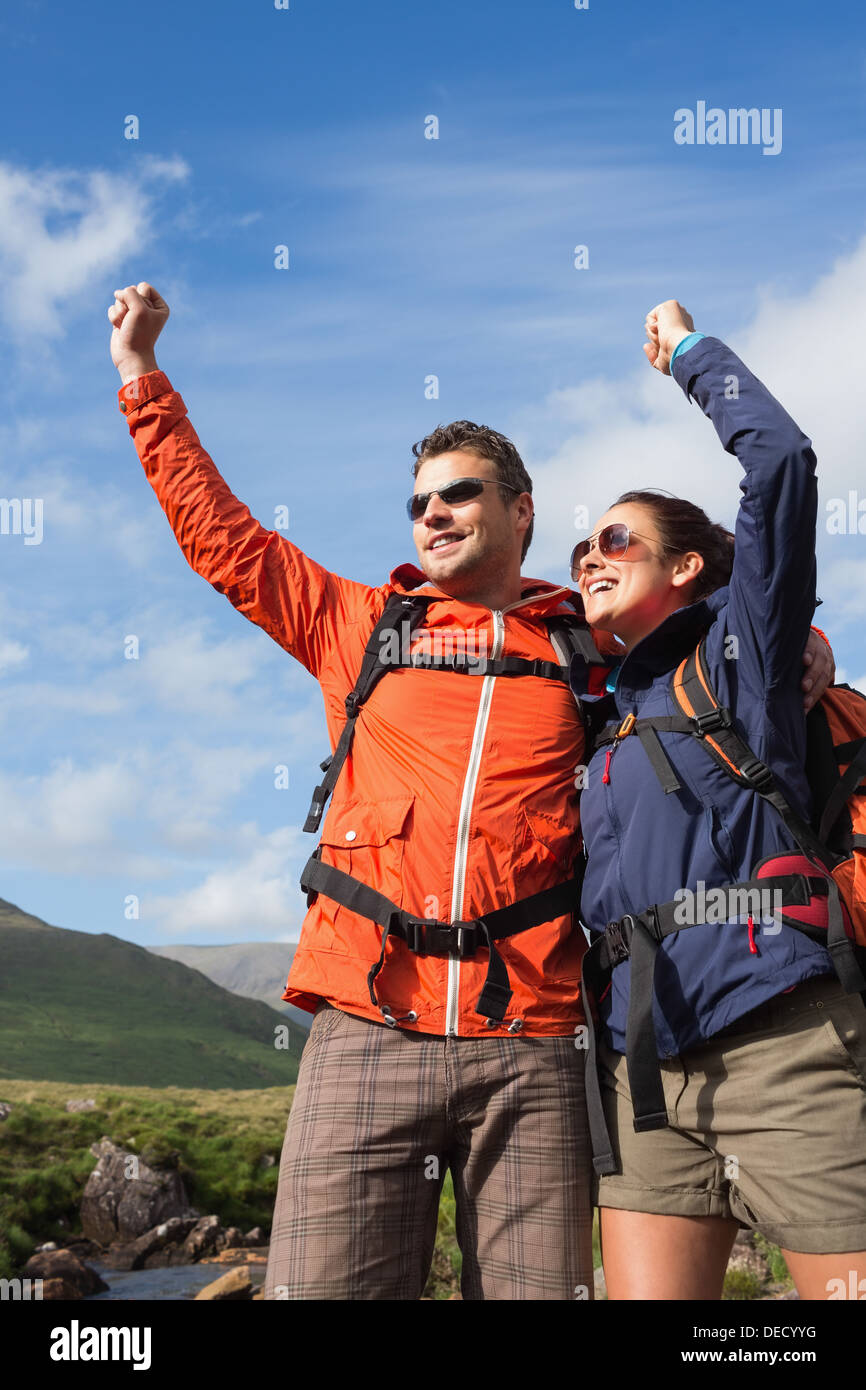 Couple on hike cheering and smiling Stock Photo - Alamy